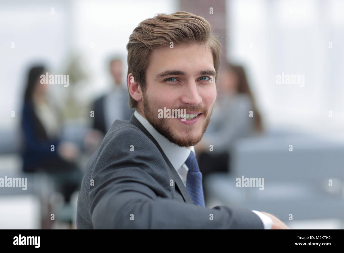 Successful business man standing with his staff in background at Stock ...