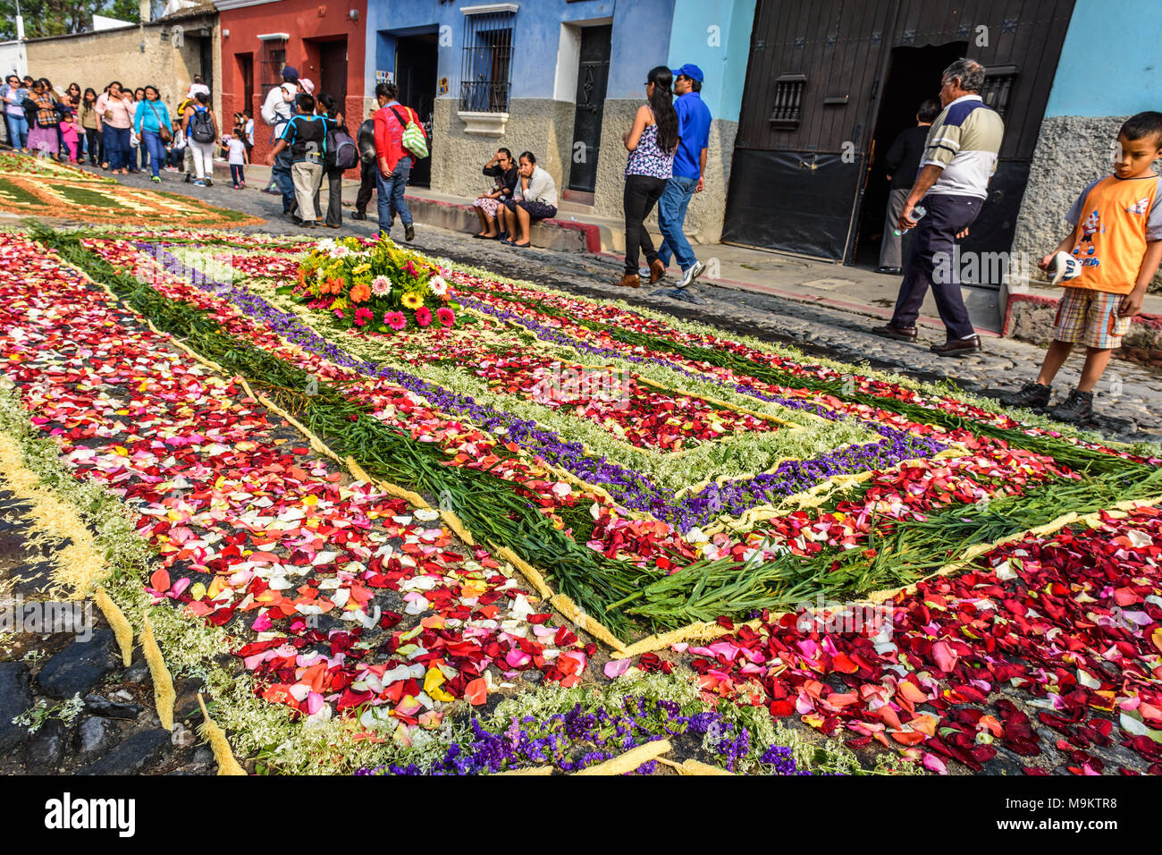 Antigua, Guatemala - March 13, 2016: Locals walk past handmade flower ...