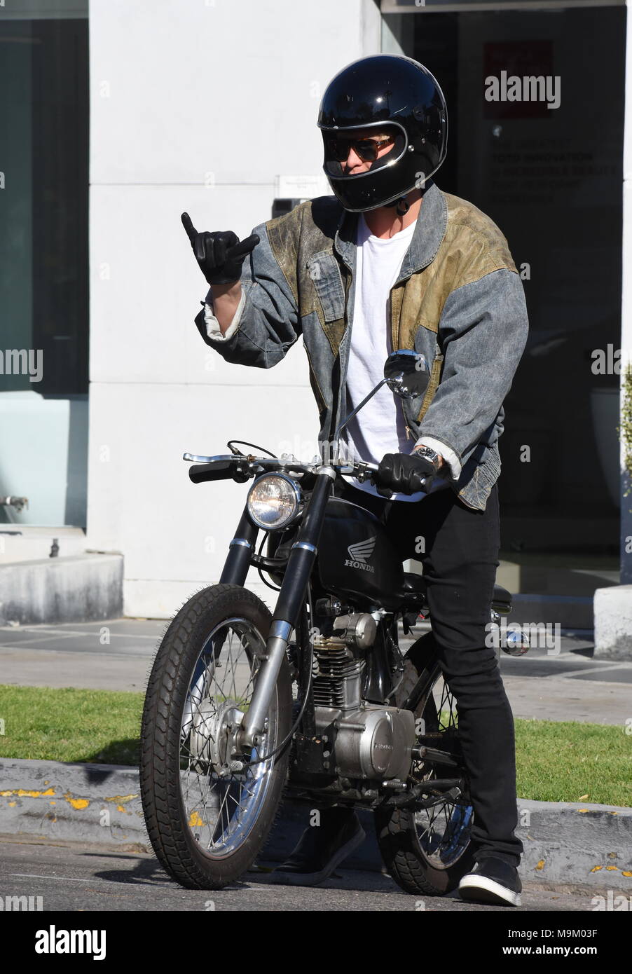 Cody Simpson gets on his motorcycle after chatting to a friend in ...