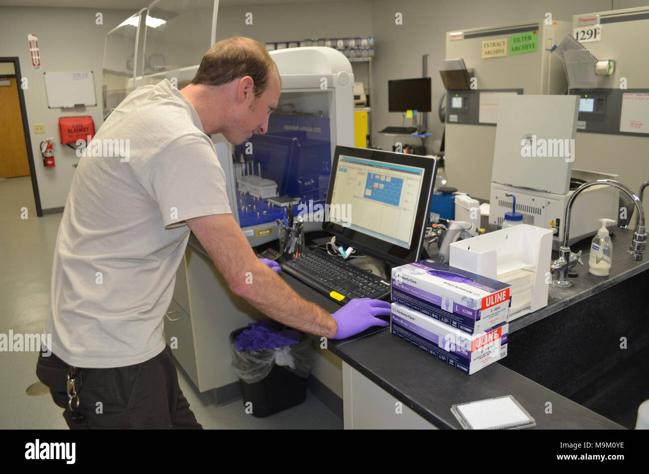 Nick Berndt running a robot, called an automated liquid handling system, that assists with eDNA ...