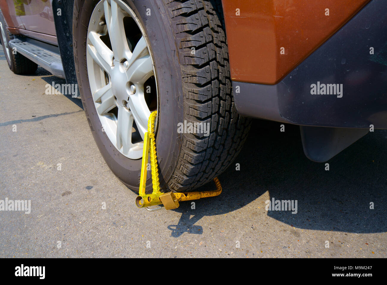 Car wheel blocked by wheel lock because illegal parking violation Stock ...