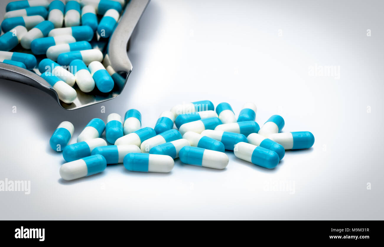 Blue and white capsules pills and drug tray on white background with ...