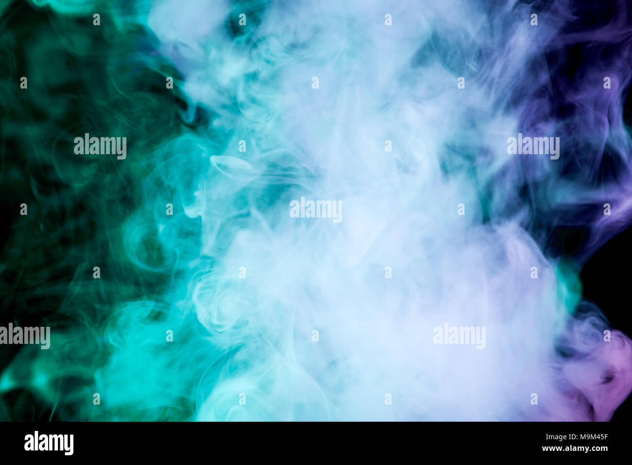 Dense multicolored smoke of blue and purple colors on a black isolated ...