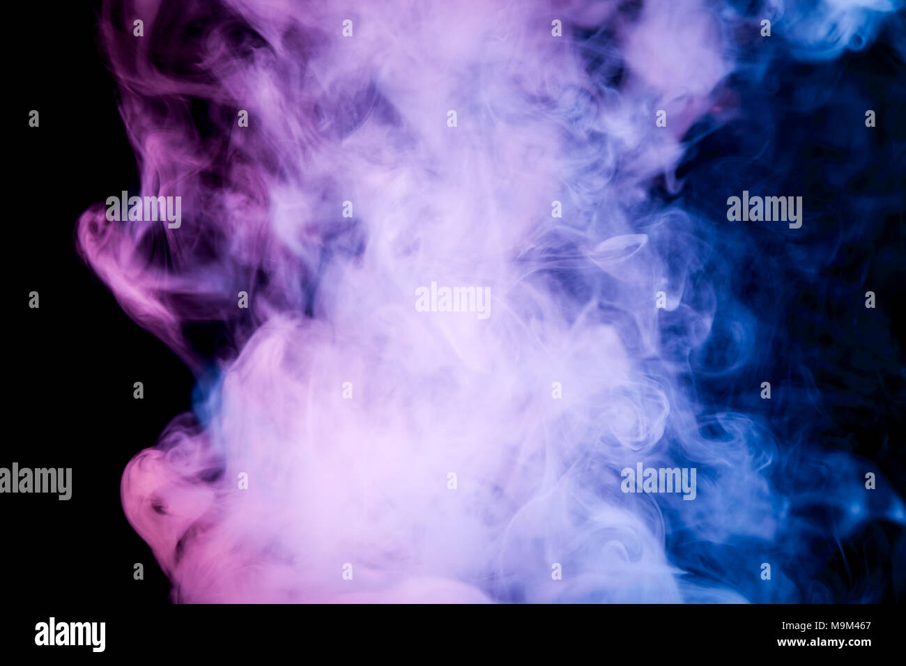 Dense multicolored smoke of blue and purple colors on a black isolated ...