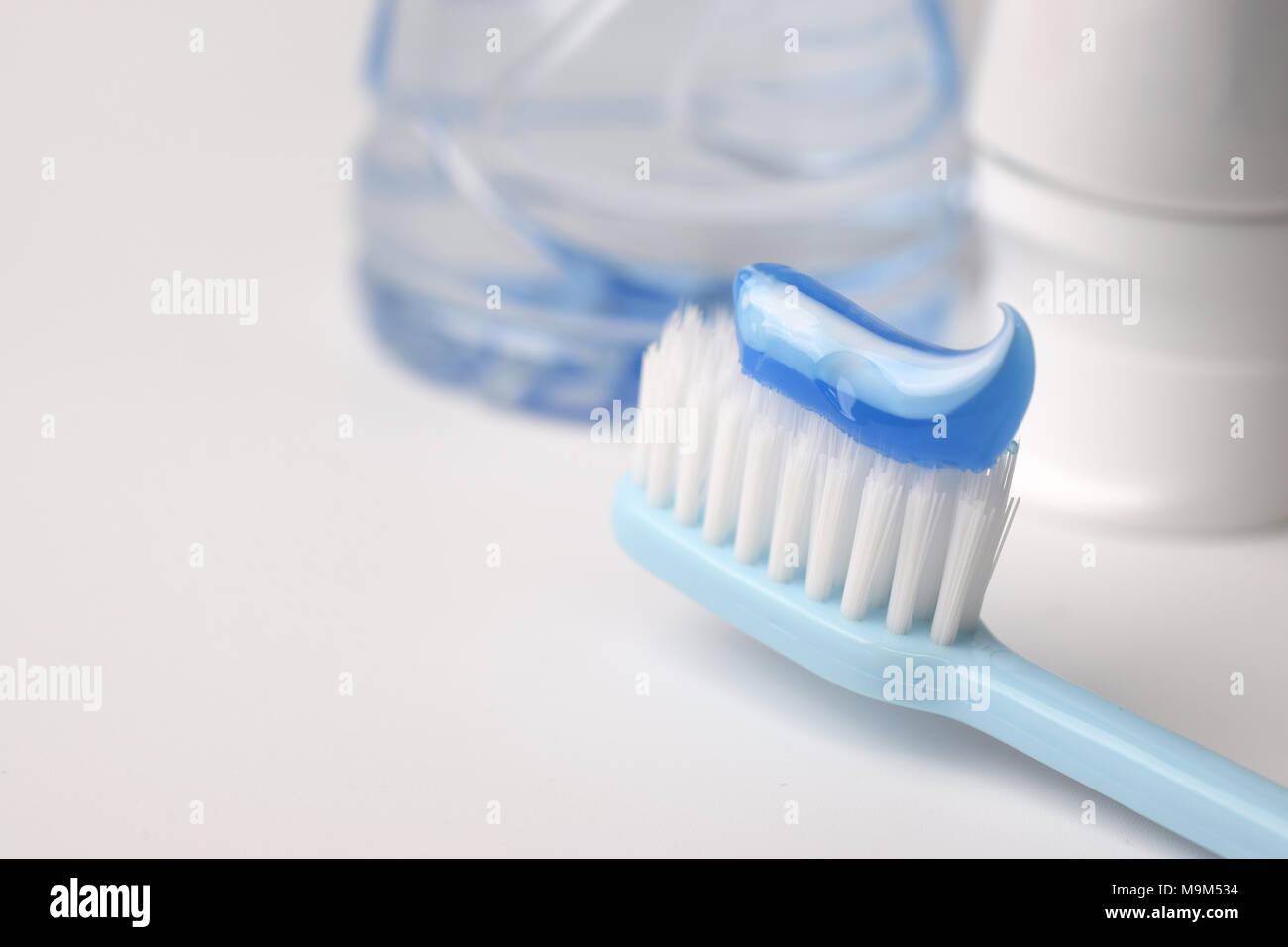Blue toothpaste on a toothbrush on white background - closeup Stock ...