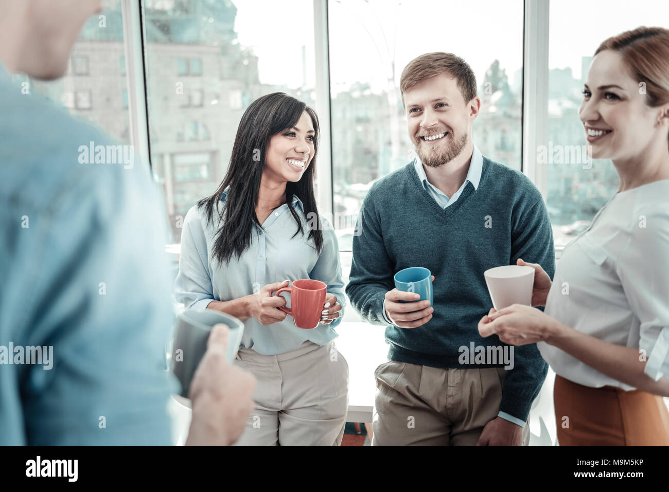Funny friendly employees smiling and spending time together Stock Photo ...