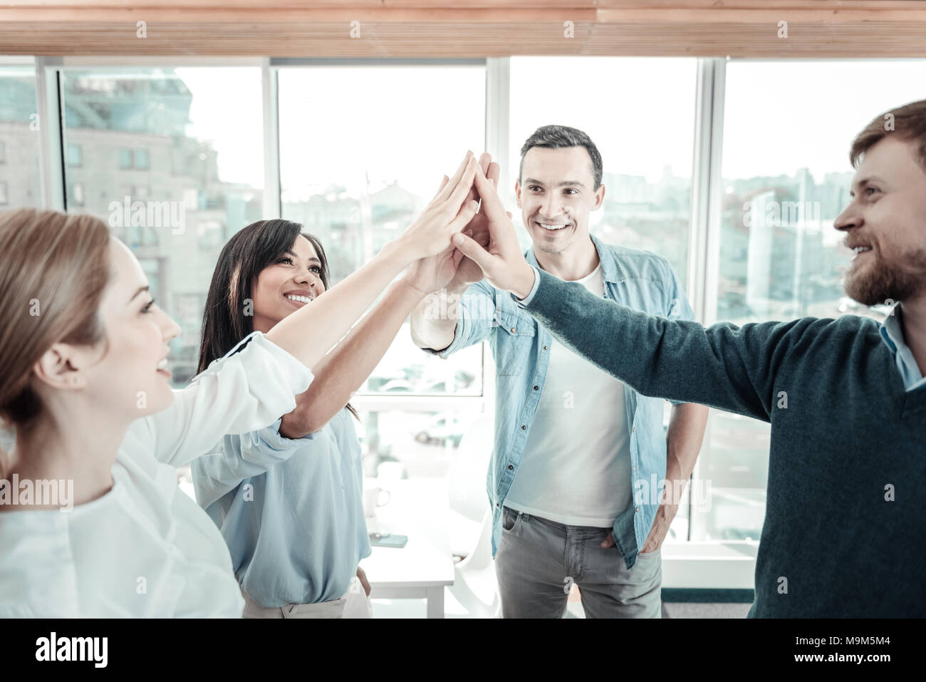 Funny reliable friends standing and holding hands up Stock Photo - Alamy