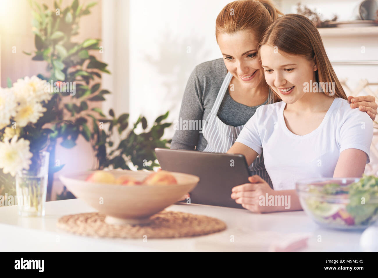 Kind female person embracing her daughter Stock Photo - Alamy