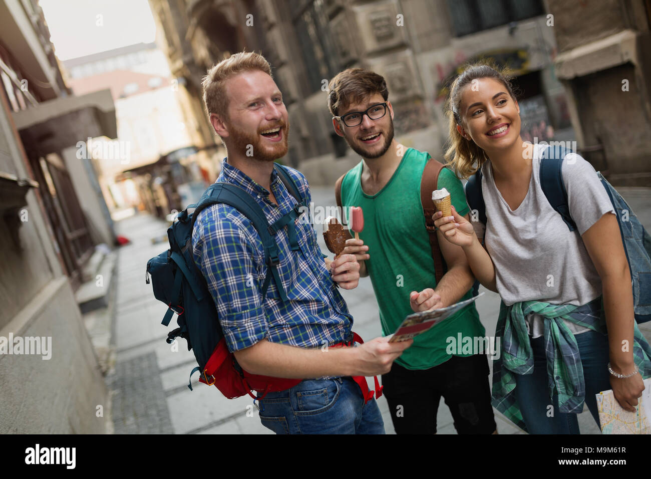 Tourist friends discovering city on foot Stock Photo - Alamy