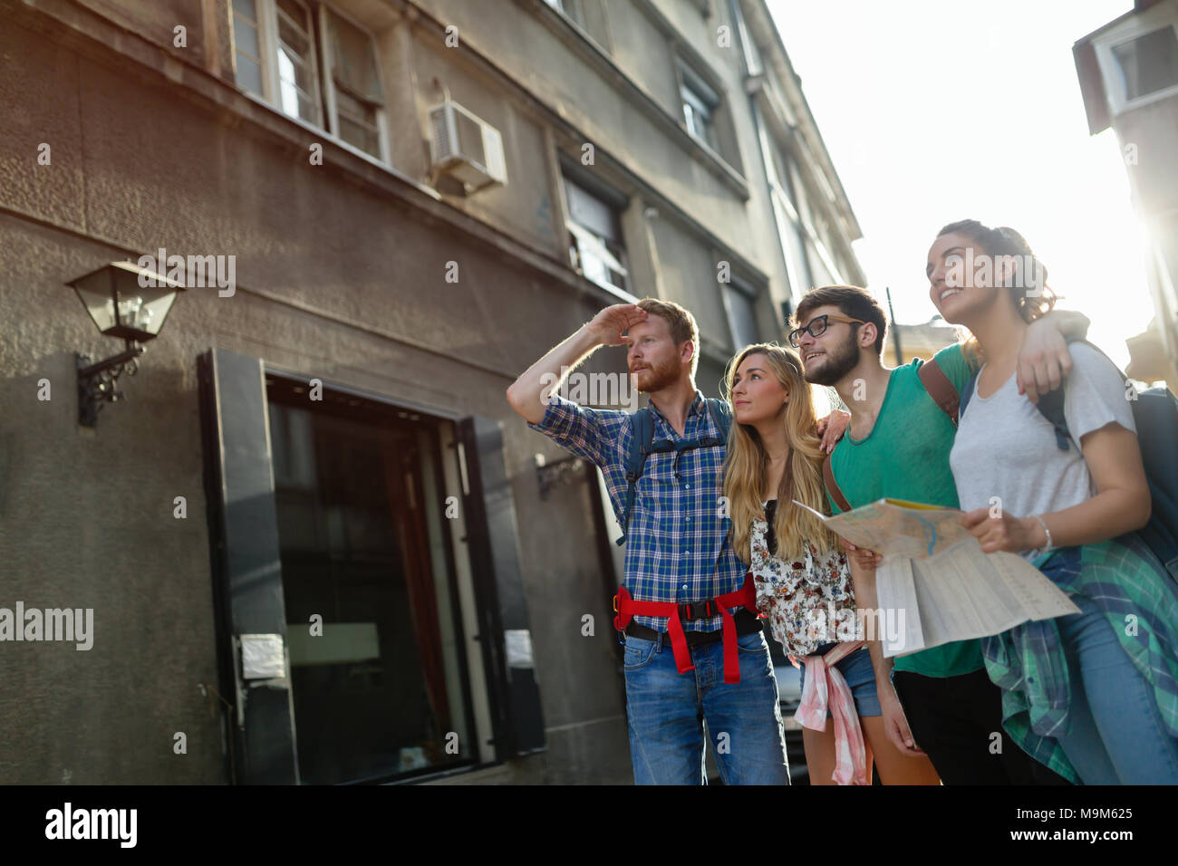 Tourist friends discovering city on foot Stock Photo - Alamy