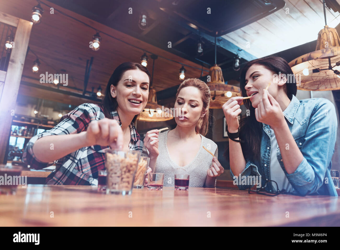 Joyful happy women eating French fries Stock Photo - Alamy