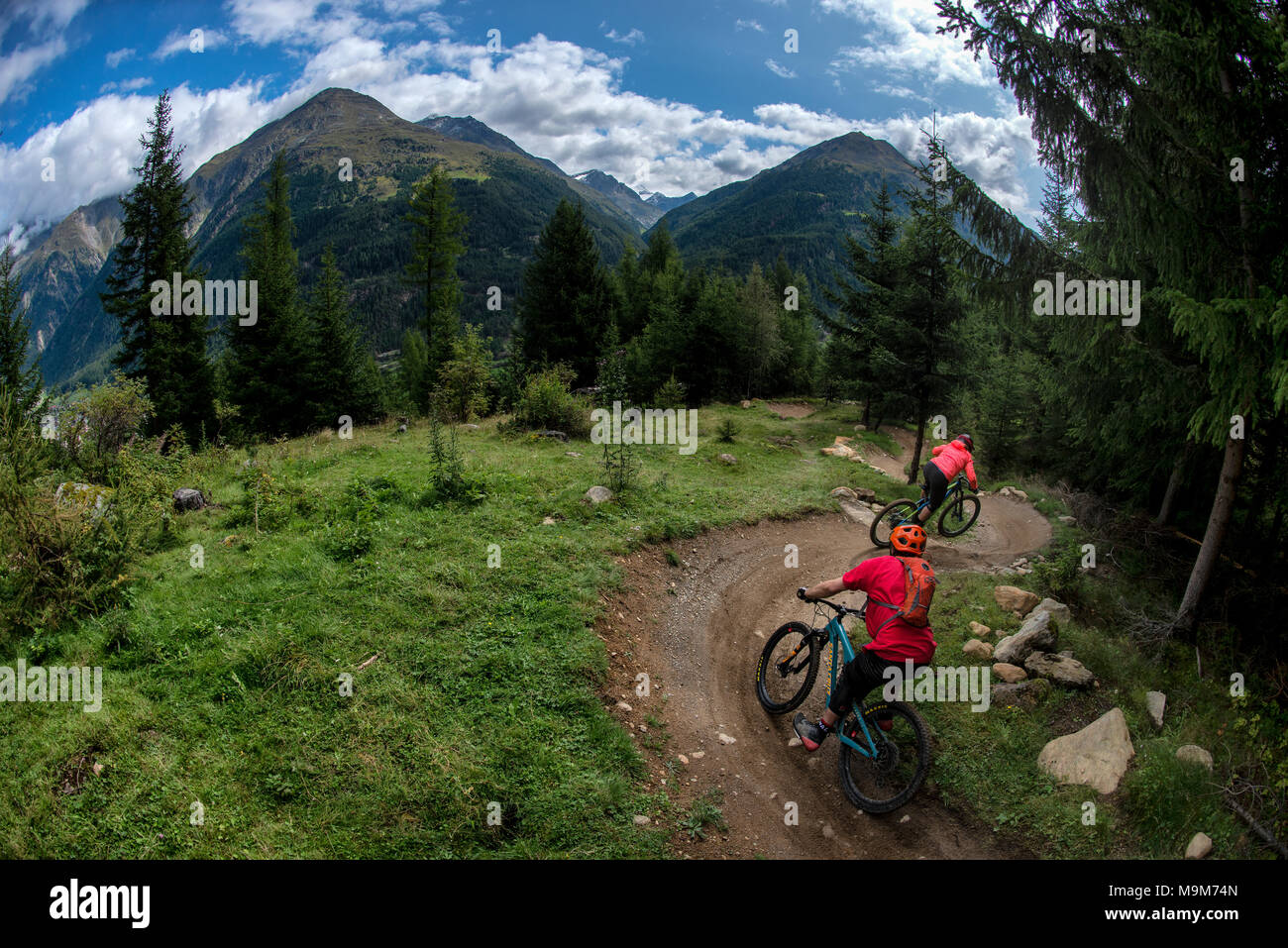 Two mountain bikers ride a trail in the Austrian alpine resort of ...