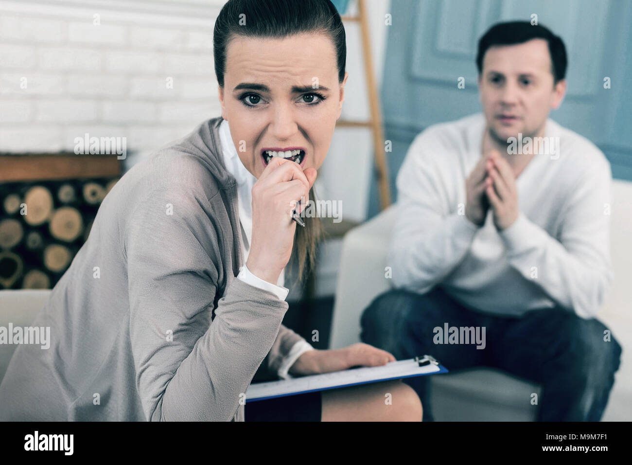 Attractive female person biting her pen Stock Photo - Alamy