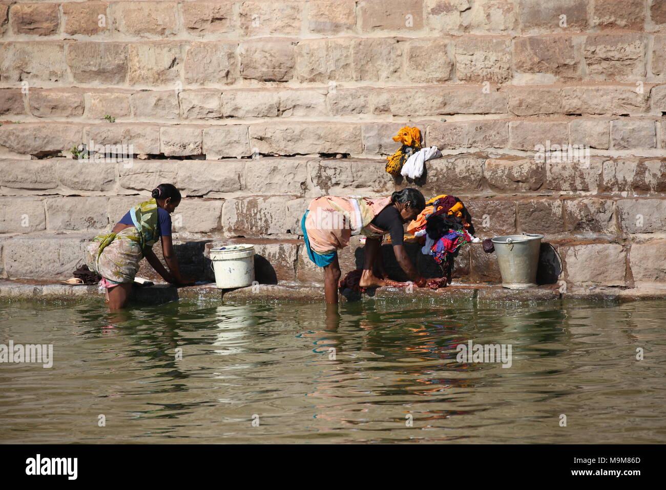 Indian woman washing clothes and dishes on the river - inderin beim ...