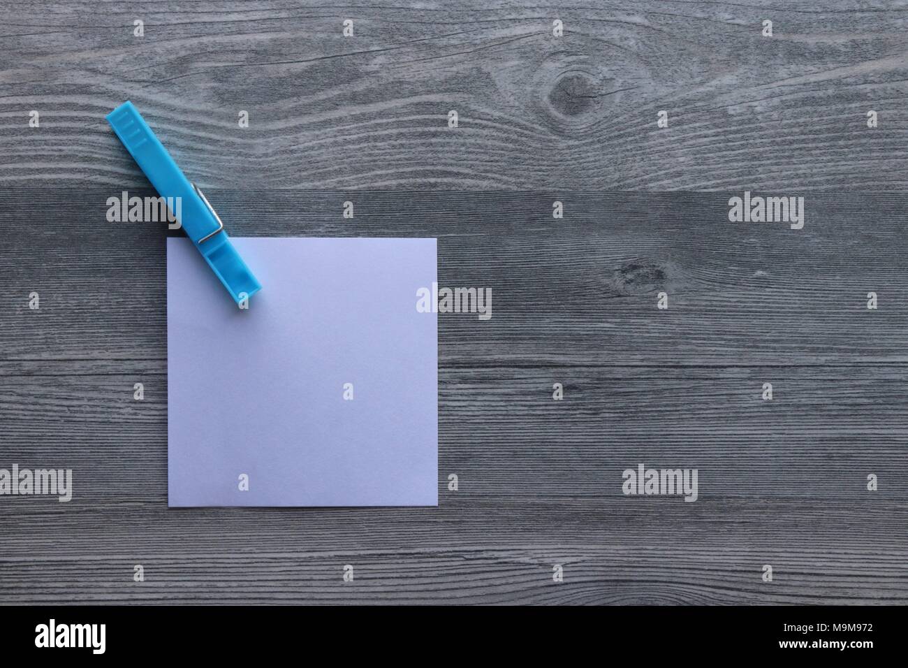 Handwritten notes on white paper, coloured clothes peg, grey plank ...