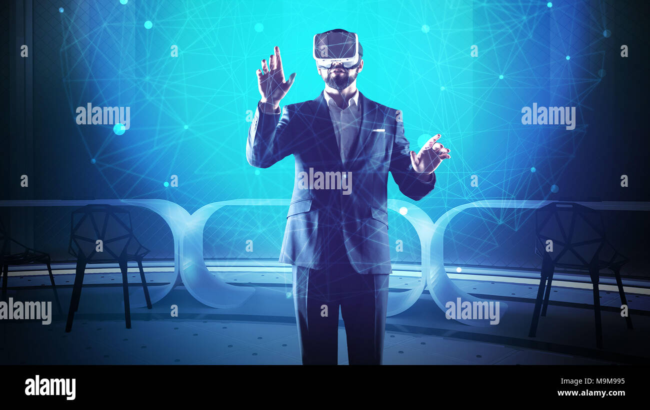 Attentive man in virtual reality glasses looking at the screen and ...