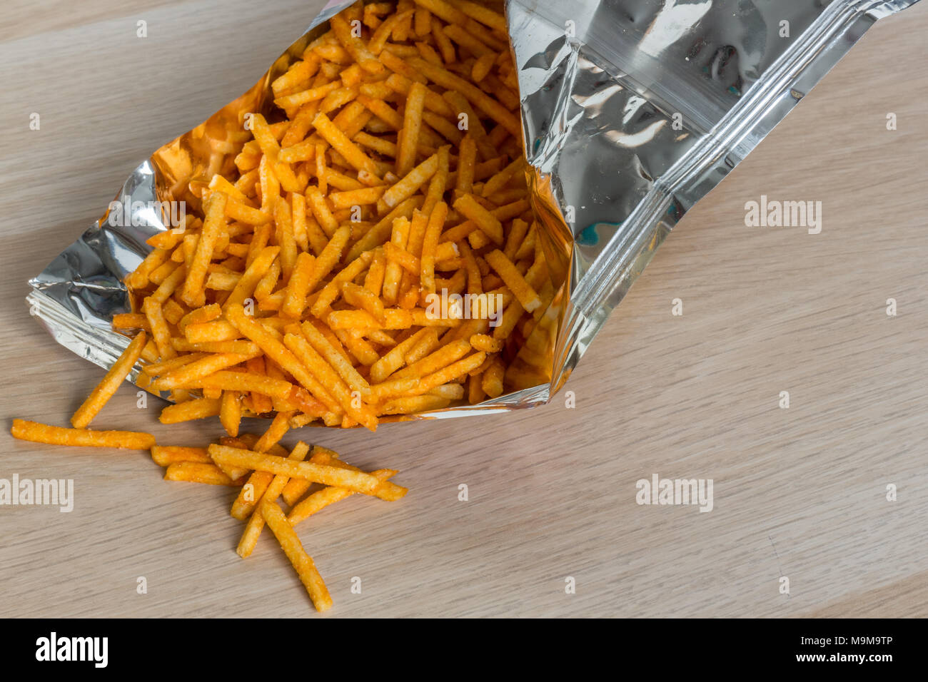 Opened pack of salty pepper stick snack on wooden table Stock Photo - Alamy