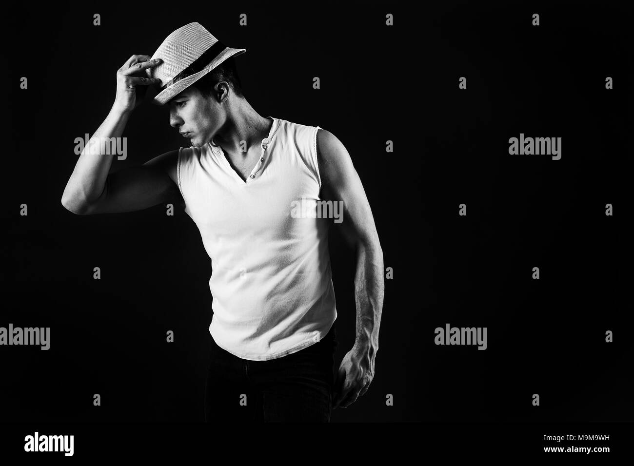 Man fashion model, stylish young man wearing fedora hat standing posing ...