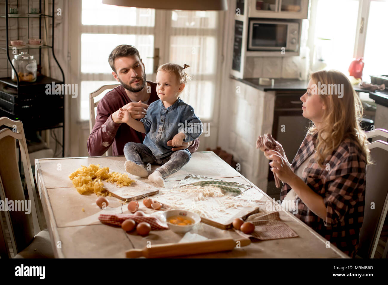 Happy family making pasta in the kitchen at home Stock Photo - Alamy