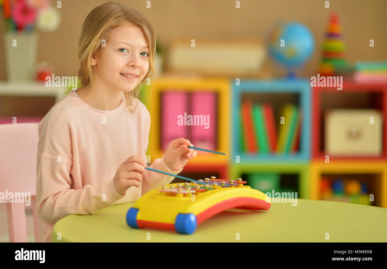 Cute little girl playing with musical toy Stock Photo - Alamy