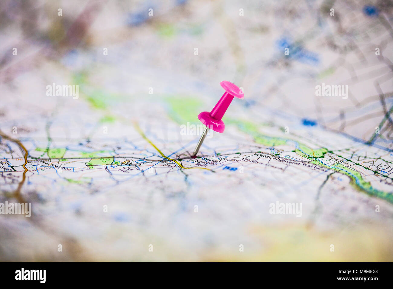 Pink pushpin showing the location of a destination point on a map ...
