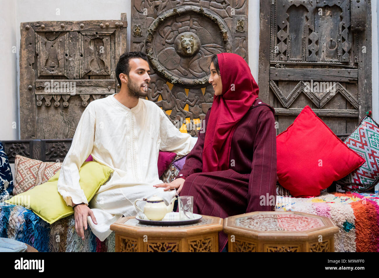 Young Muslim couple in relationship talking and smiling in traditional ...