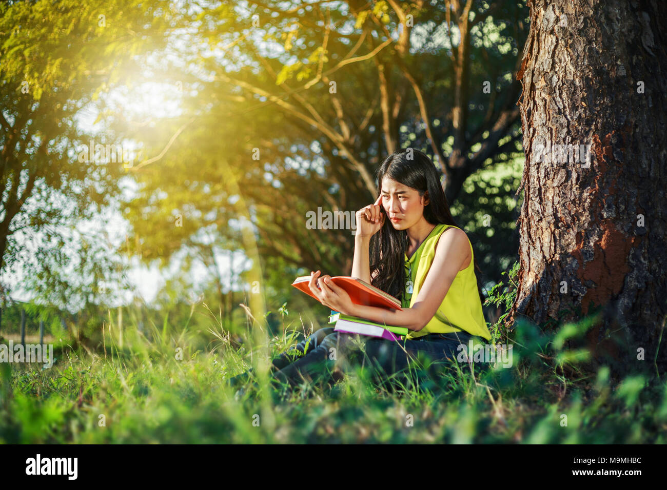 young woman in stress situation when reading a book in the park Stock ...