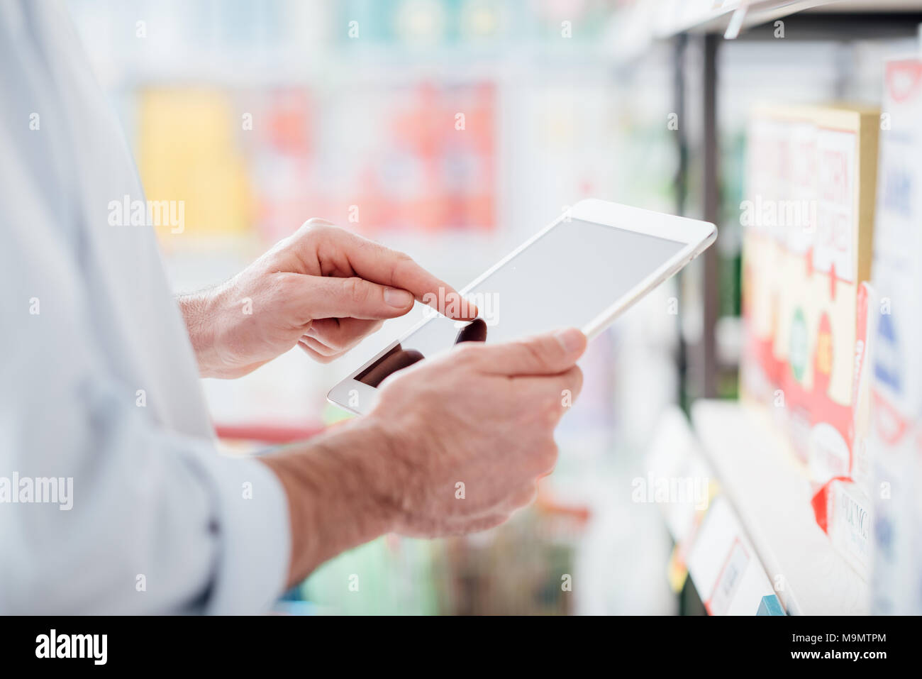 Man doing grocery shopping at the supermarket and using a digital touch ...