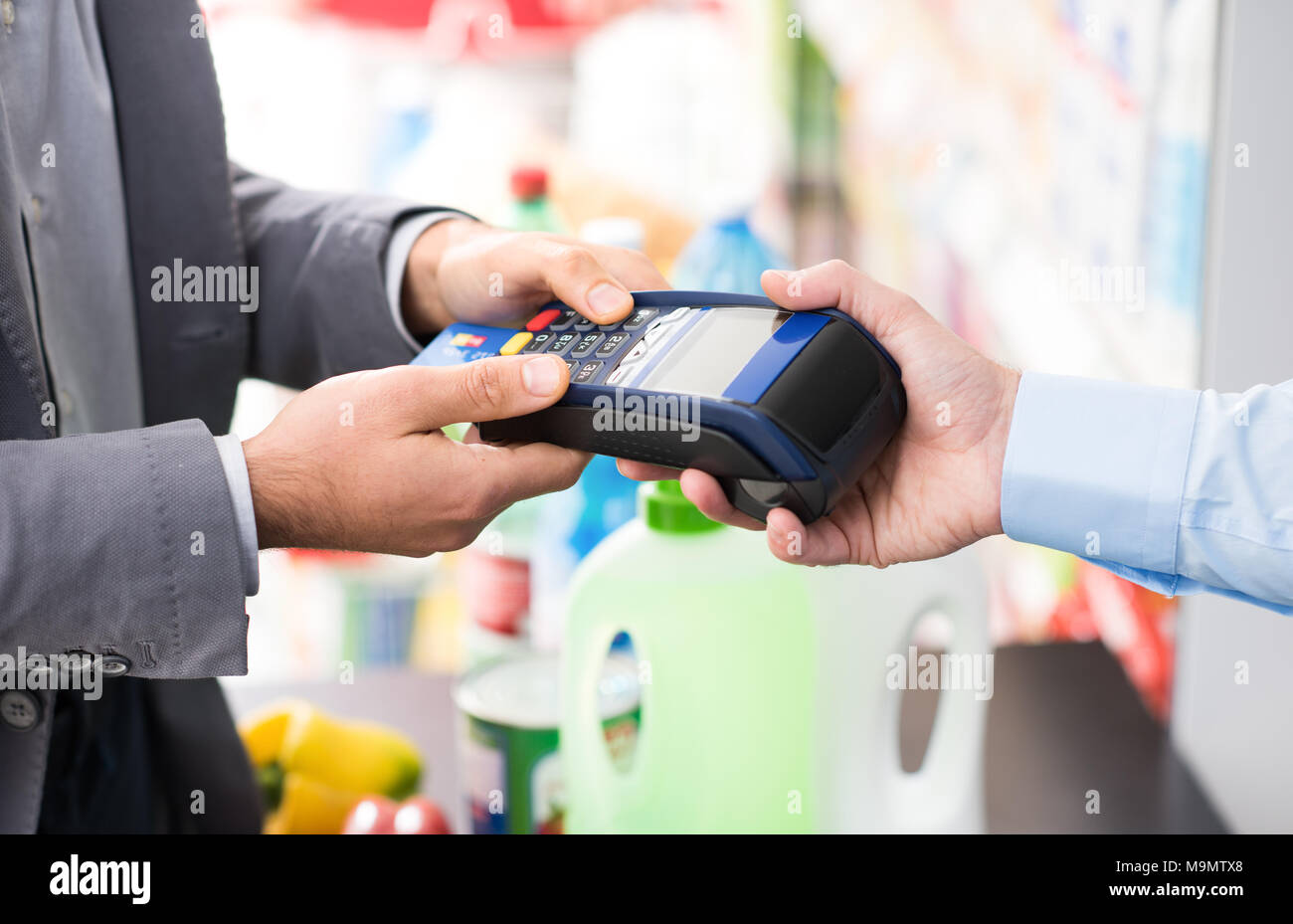 Man doing grocery shopping at the supermarket and paying with a credit ...