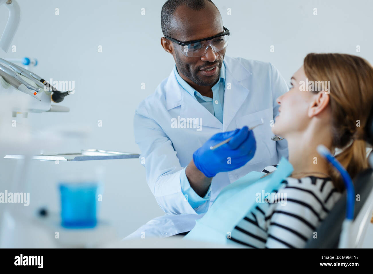 Clear explanation. Charming young woman listening to her male dentist ... Clear explanation. Charming young woman listening to her male dentist ...