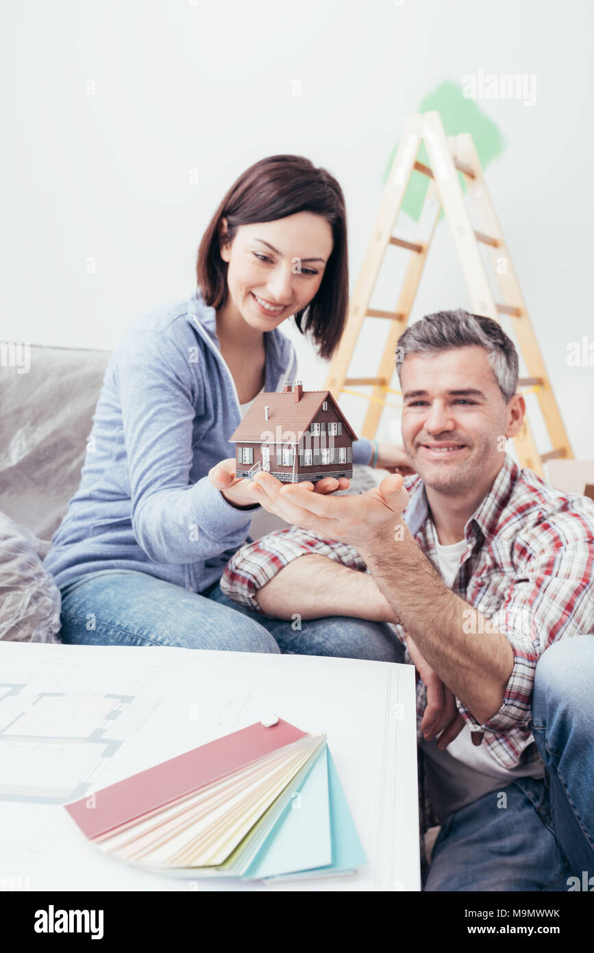 Couple building their dream house: they are holding a model house ...