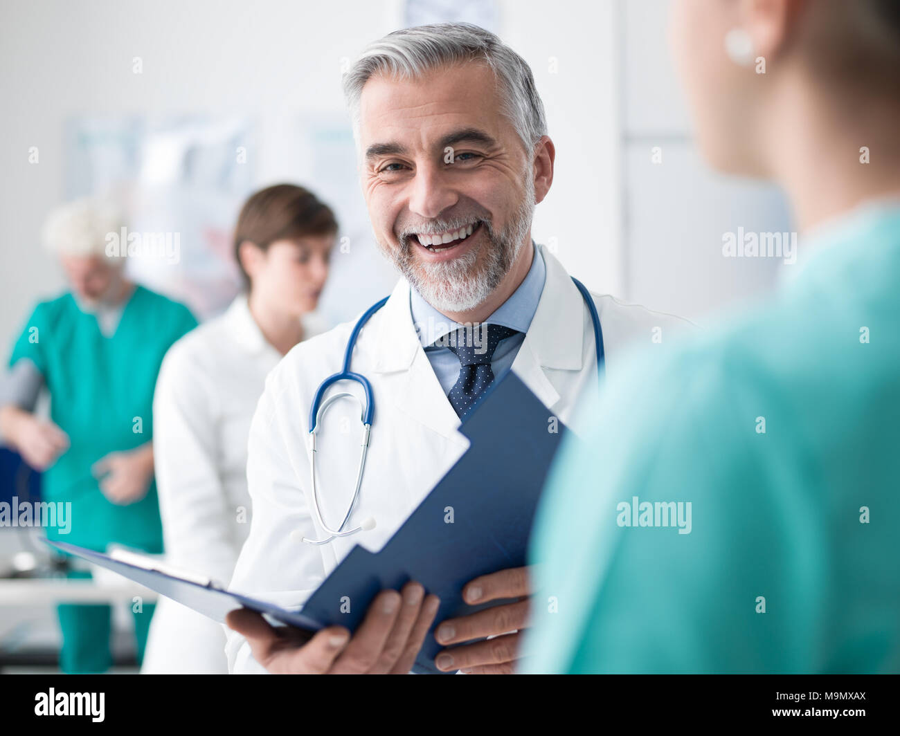 Smiling professional doctor and medical staff working at the hospital ...