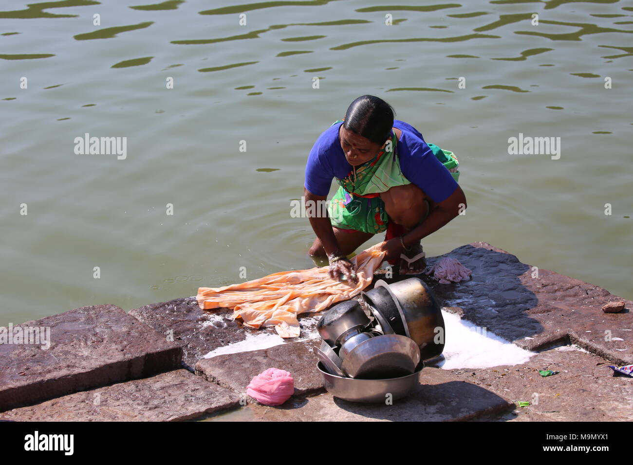 Indian woman washing clothes and dishes on the river - inderin beim ...