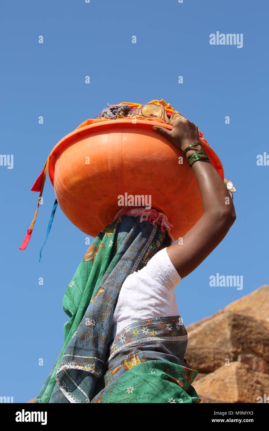 Indian woman after washing clothes with wash bowl on her head ...