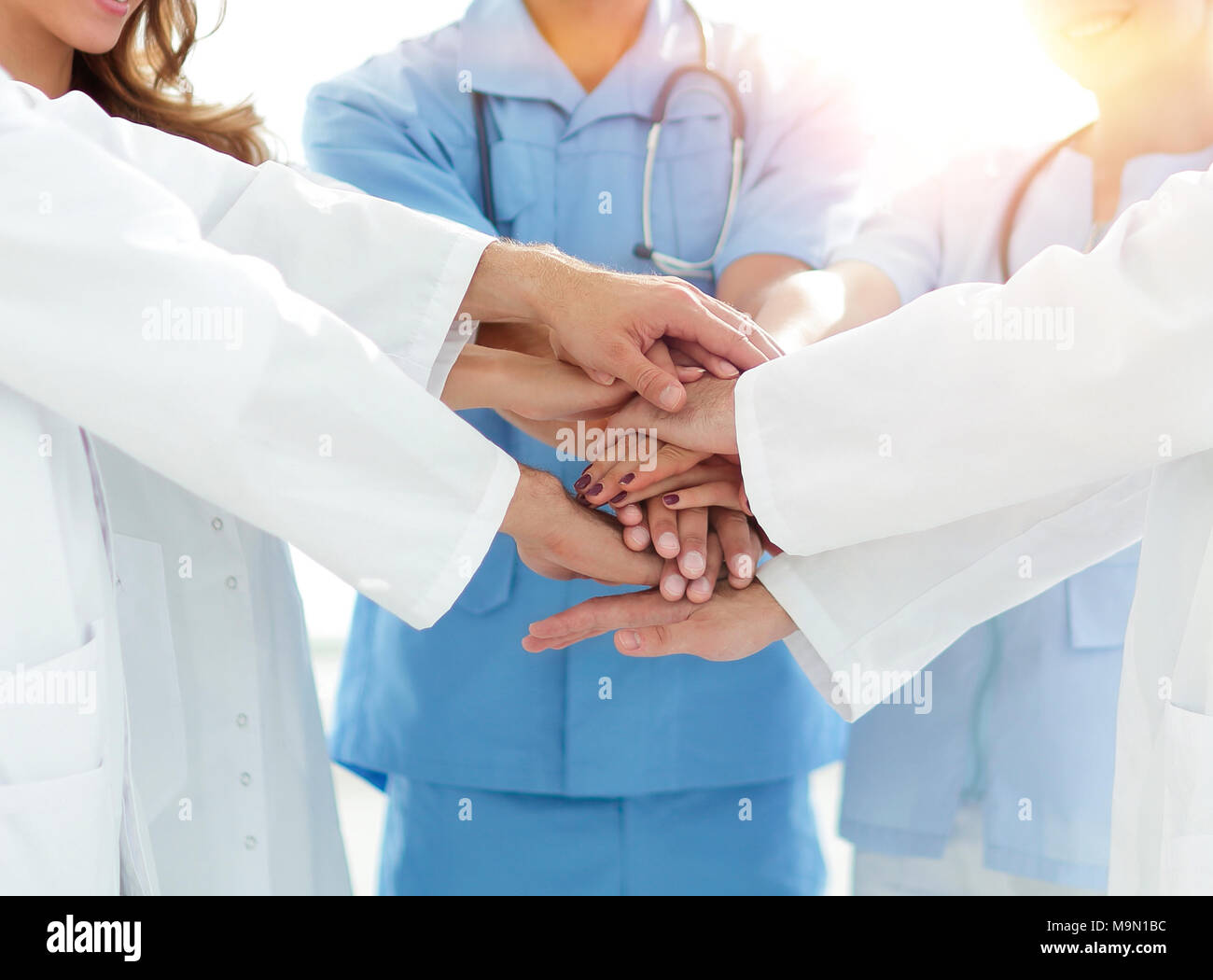 Doctors and nurses stacking hands. concept of mutual aid Stock Photo ...