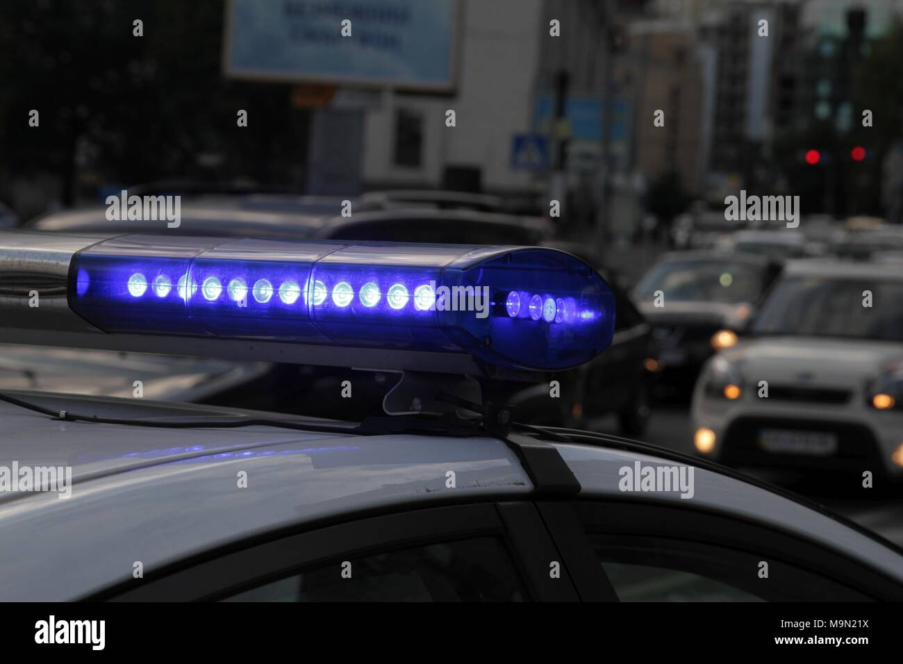 Police car with lights turned on. City lights on the background. With ...