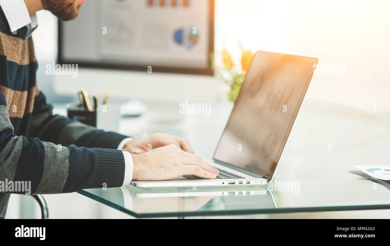 Finance specialist working on laptop with financial charts and ...