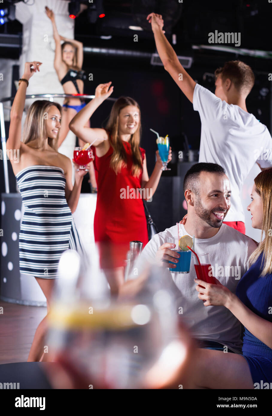 Happy cheerful positive smiling female and male clubbing with cocktail ...