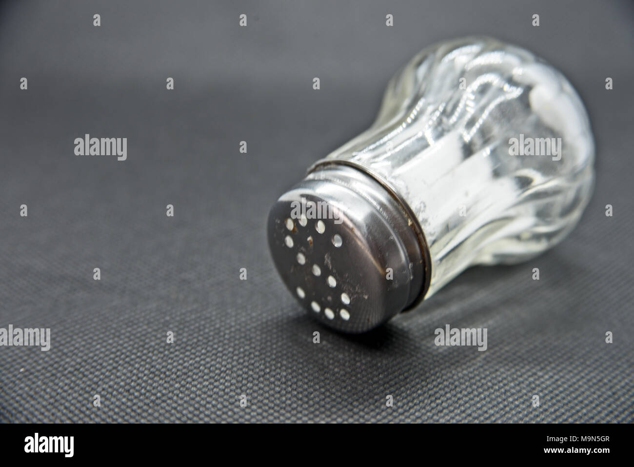 Salt shaker made of glass against a black background Stock Photo - Alamy