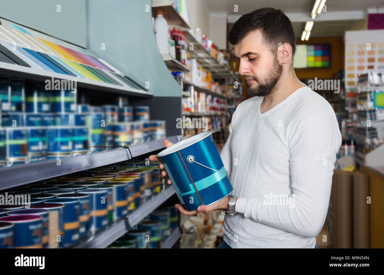 Man is deciding on best wall paint in paint supplies store Stock Photo ...