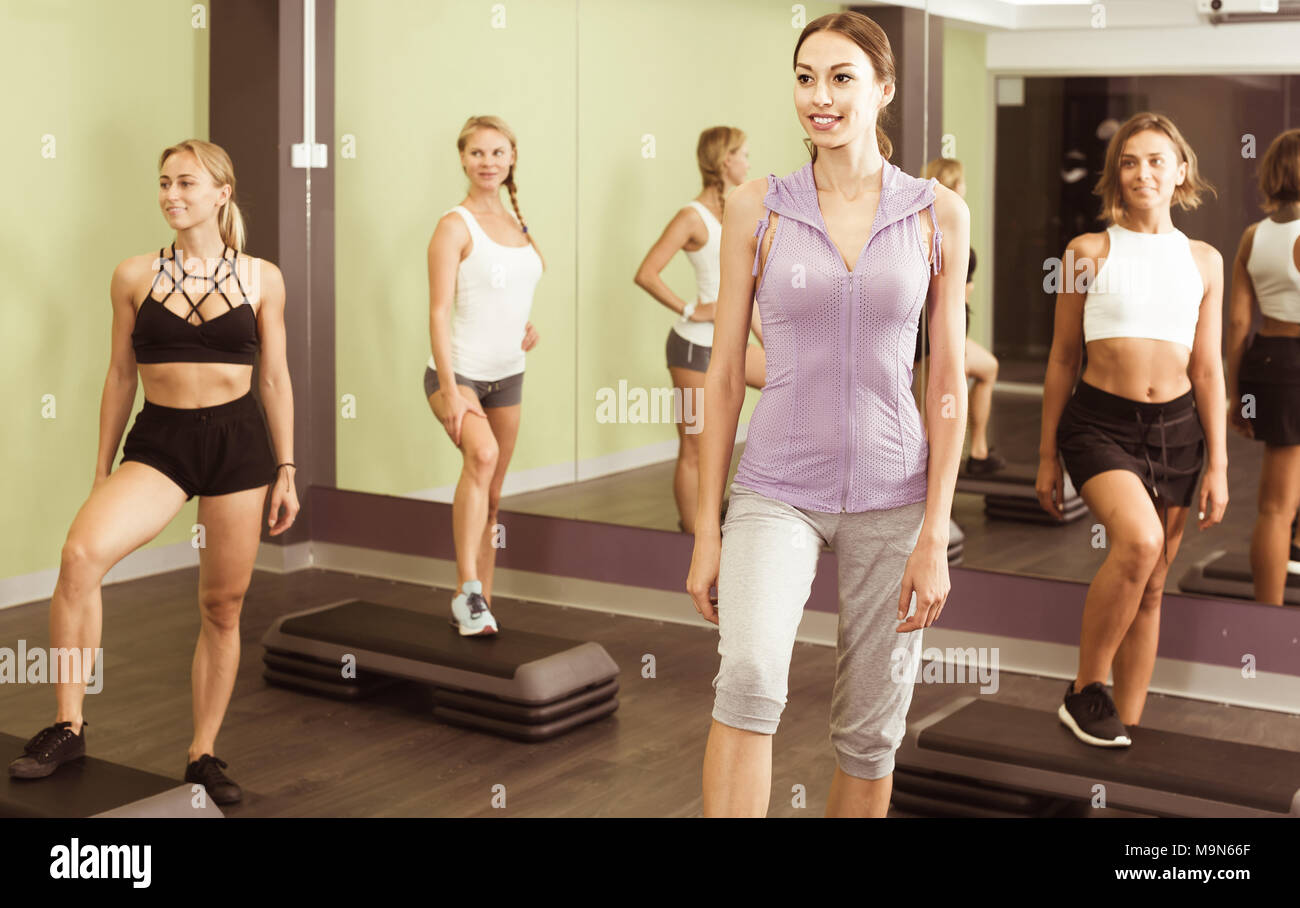 Portrait of young russian fit woman performing step aerobics in fitness ...