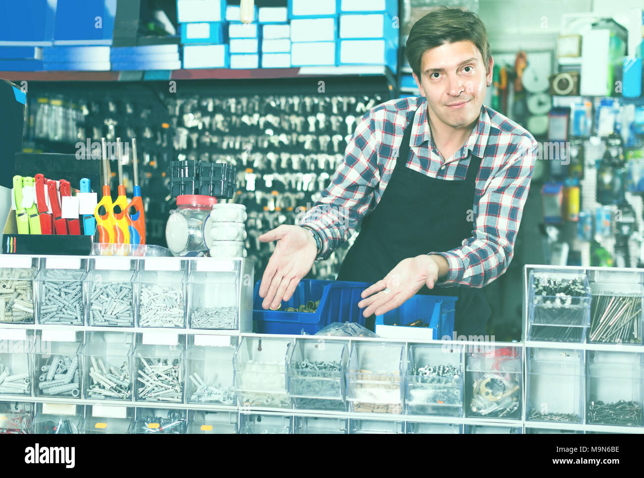 Smiling employee in hardware store is trading goods for construction in ...