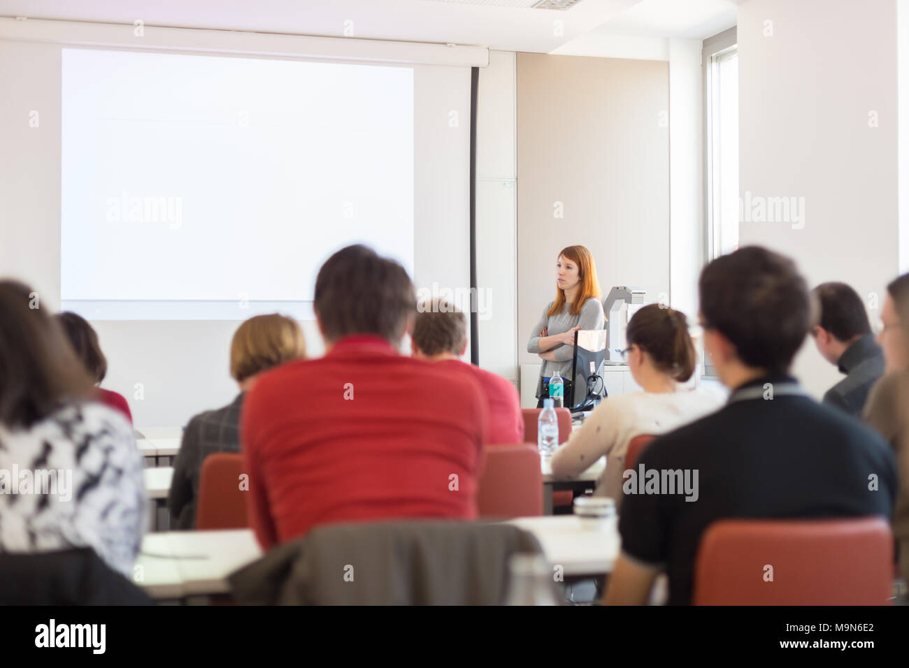 Woman giving presentation in lecture hall at university Stock Photo - Alamy