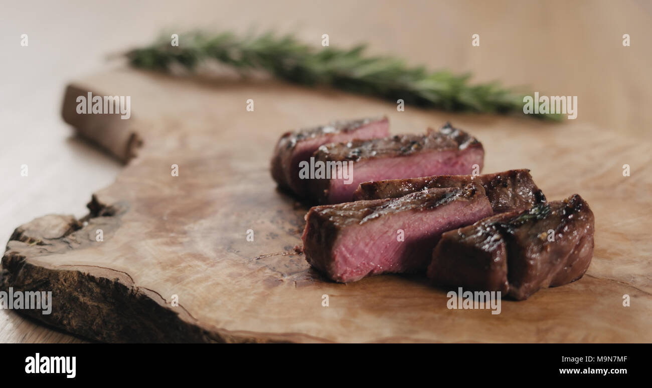 sliced medium fillet mignon steak on wood board Stock Photo - Alamy