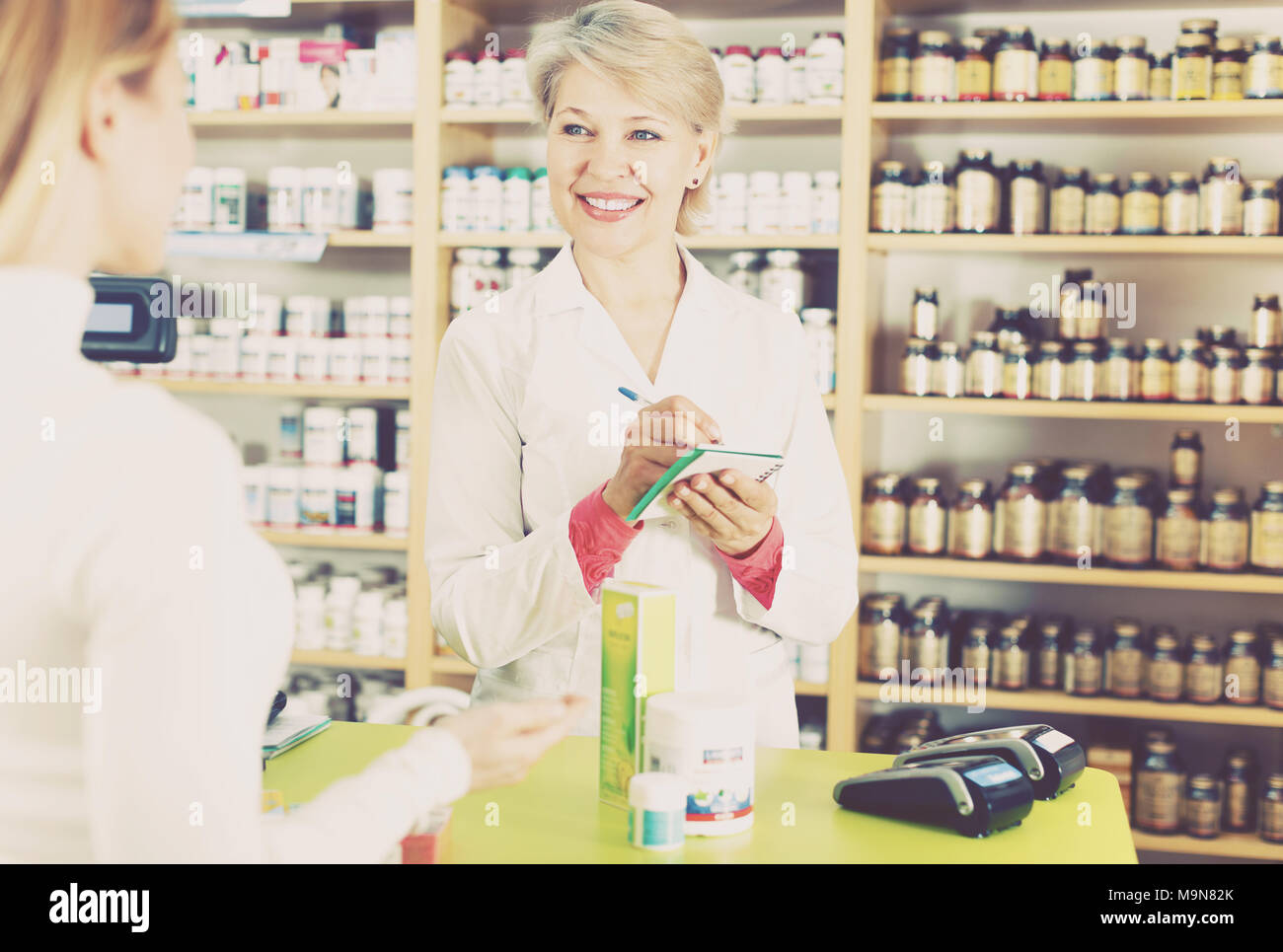 Mature female seller helping customer to choose care products in ...