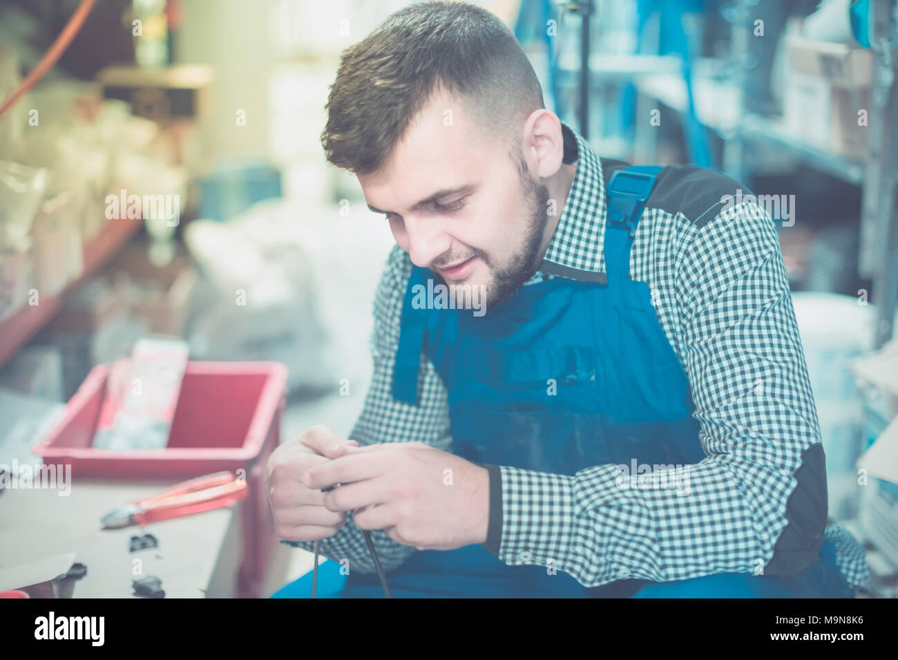 Young man worker ready to use his tools for repairing adaptor in ...