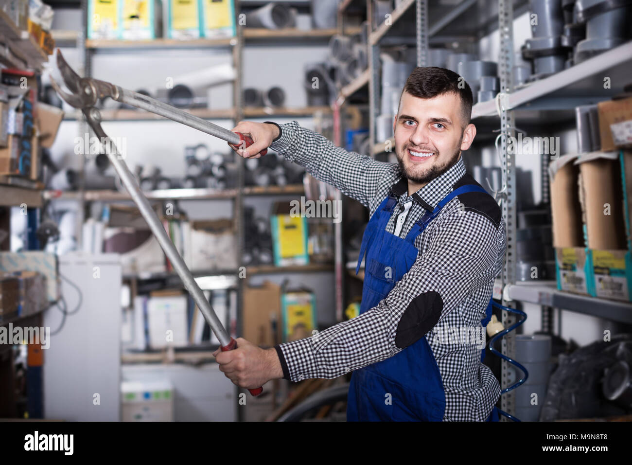 Smiling man worker showing various tools at workshop Stock Photo - Alamy