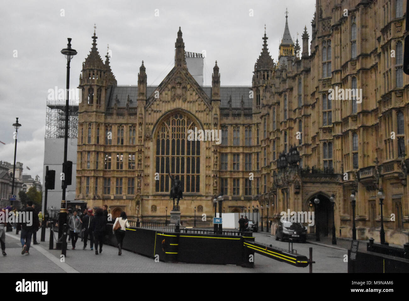 Pedestrians pass by the Palace of Westminster in London England. Crash ...