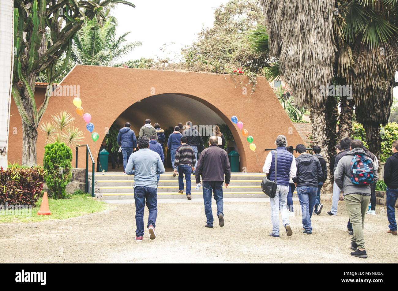 Young people entering a place through an arch entrance Stock Photo - Alamy