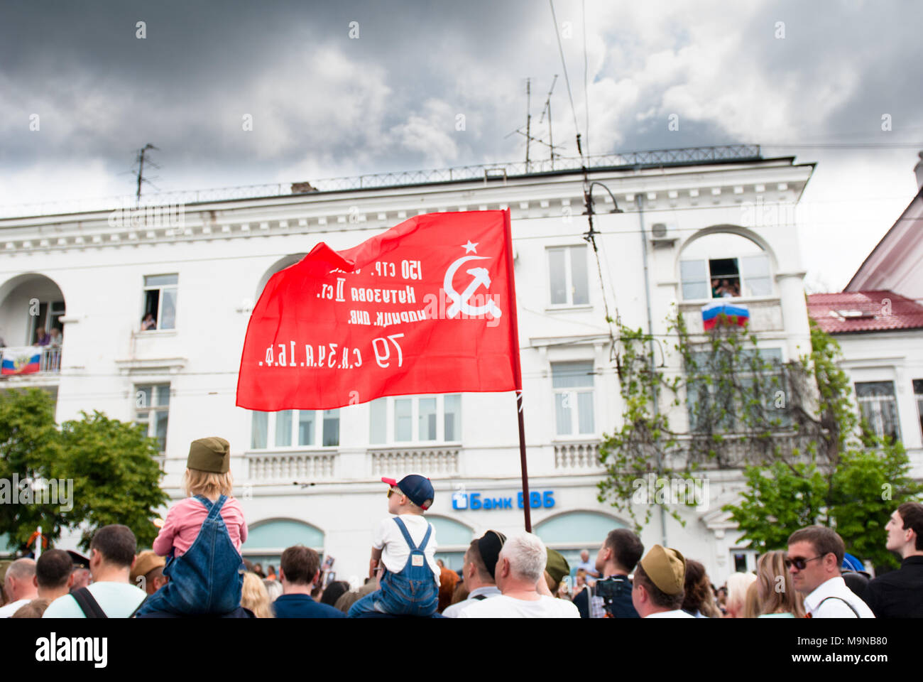 red communist flag of Red Army among people on victory day parade ...